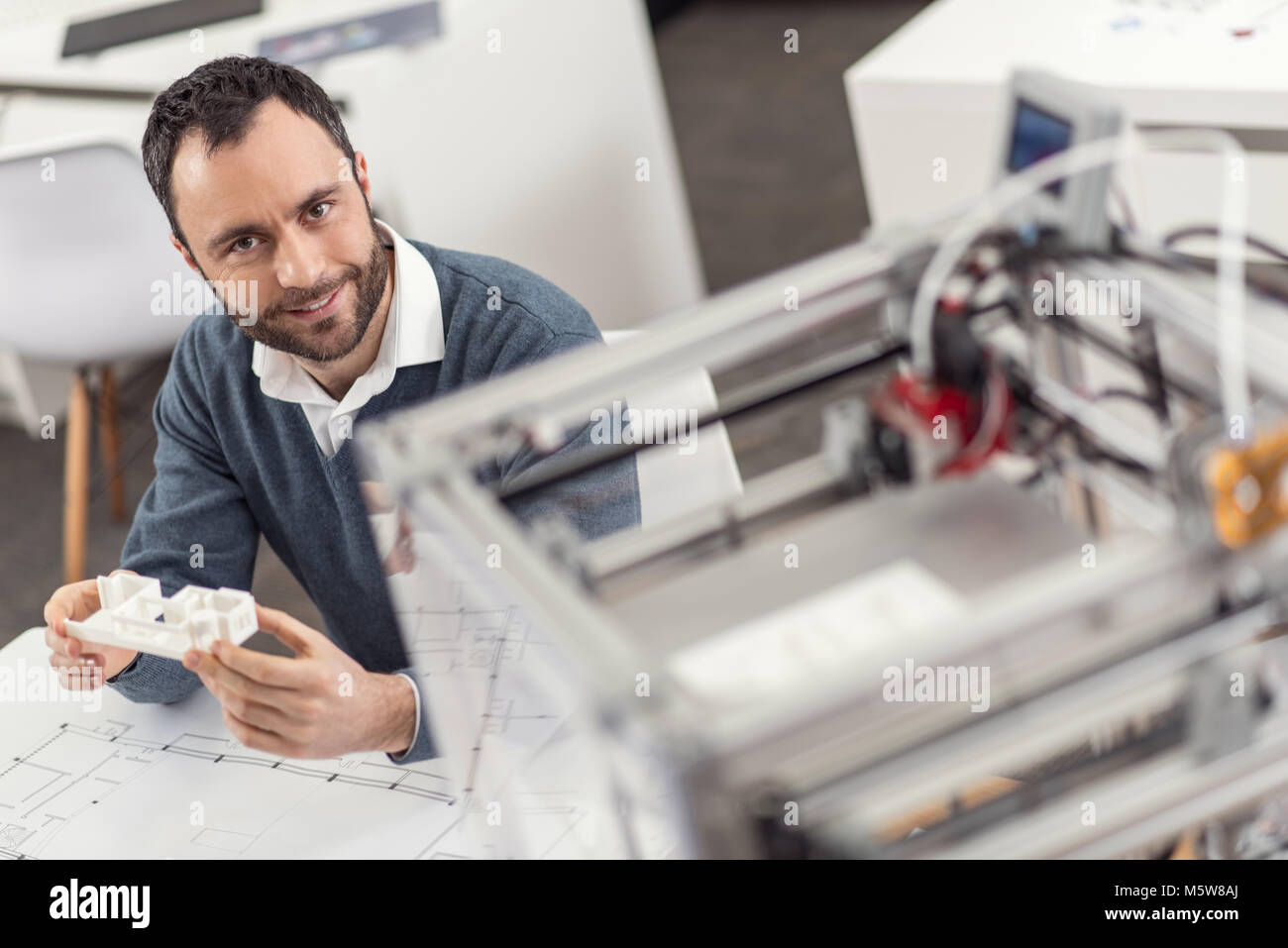Top view of smiling engineer holding 3D model Stock Photo - Alamy