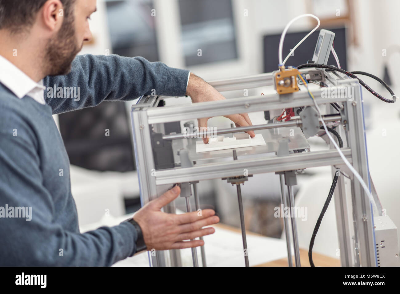 Handsome young engineer removing printed 3D model Stock Photo - Alamy