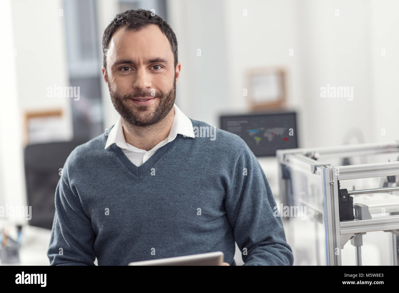 Portrait of handsome cheerful engineer posing in his office Stock Photo ...