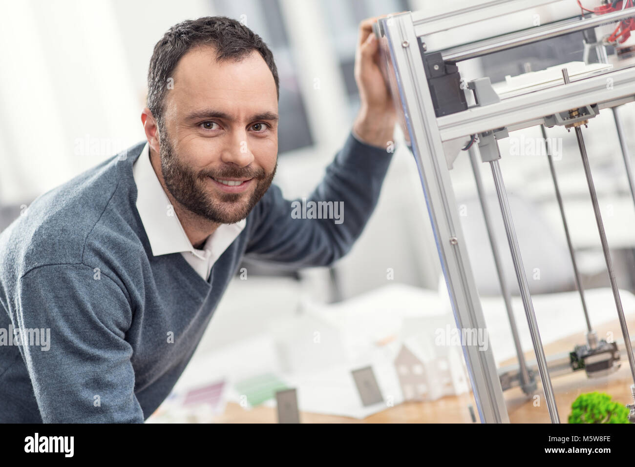 Handsome man leaning on 3D printer and smiling Stock Photo - Alamy