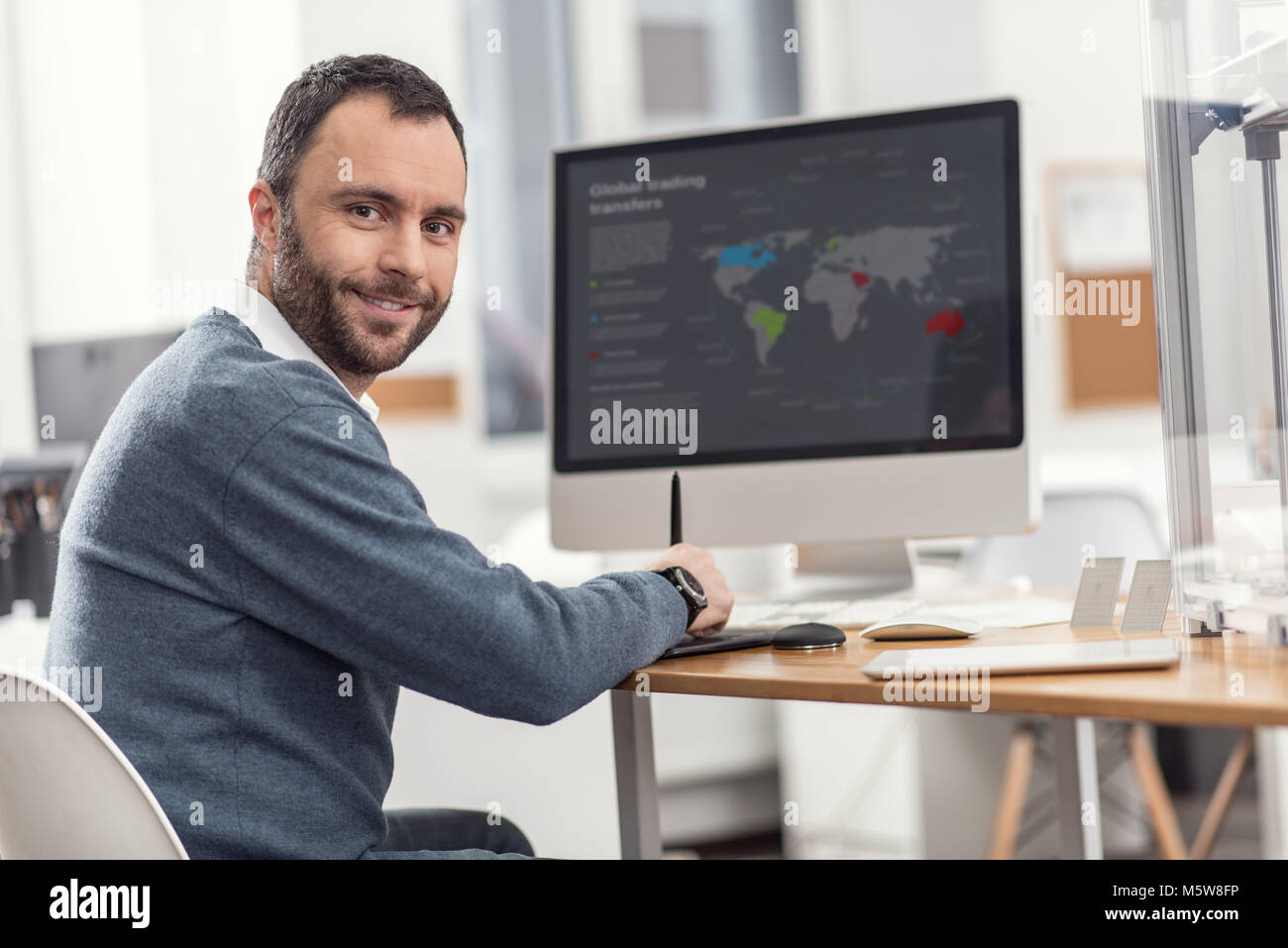 Pleasant young man posing while working on computer Stock Photo - Alamy