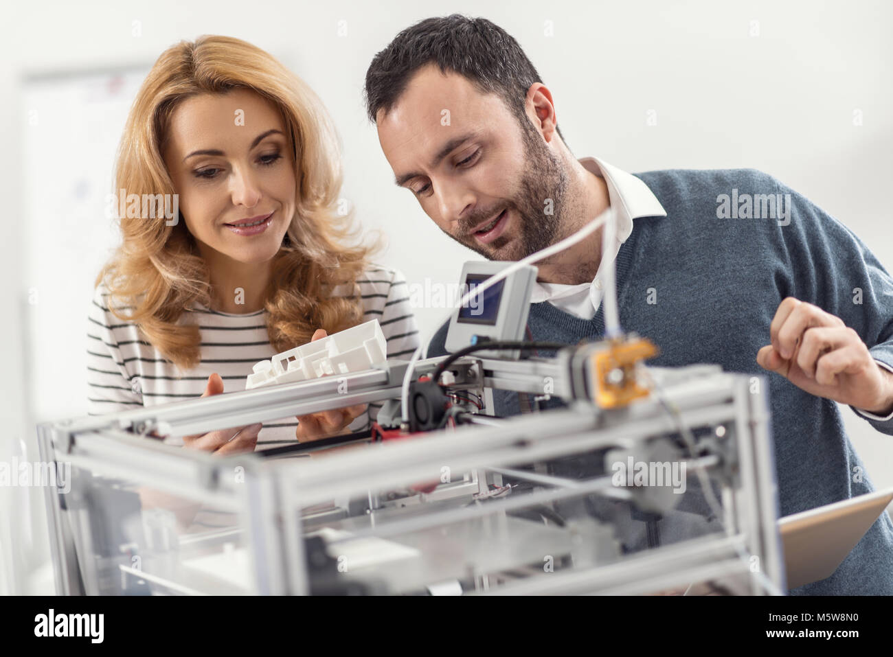 Young engineer explaining principles of 3D printer work Stock Photo - Alamy