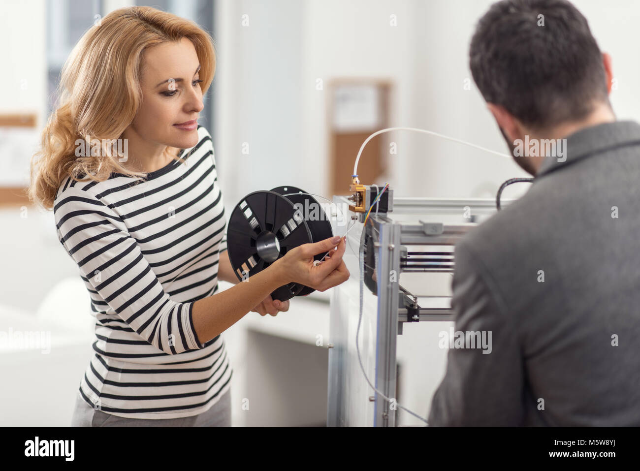 Beautiful woman holding spool and inserting filament Stock Photo - Alamy