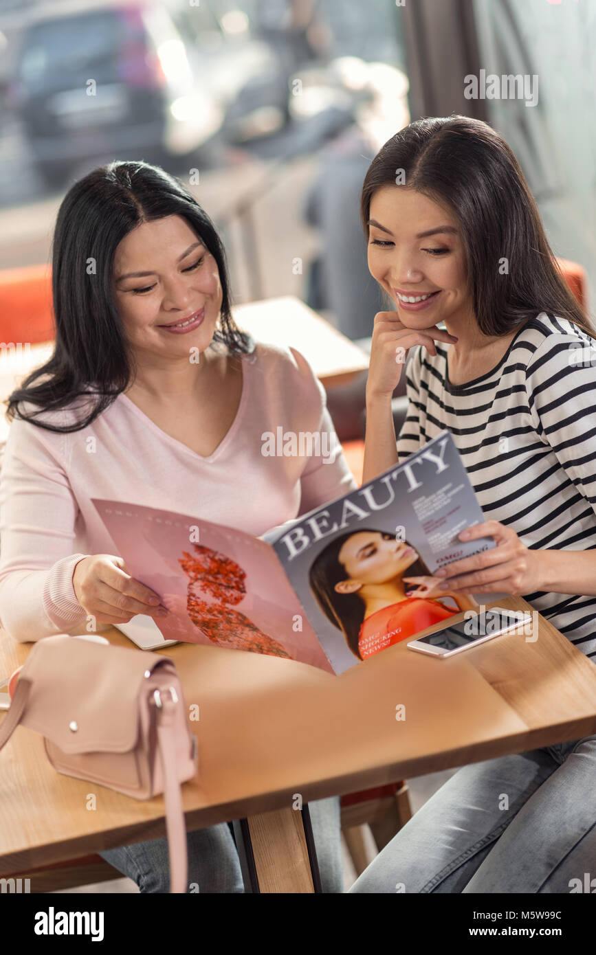 Nice happy women holding a magazine Stock Photo - Alamy