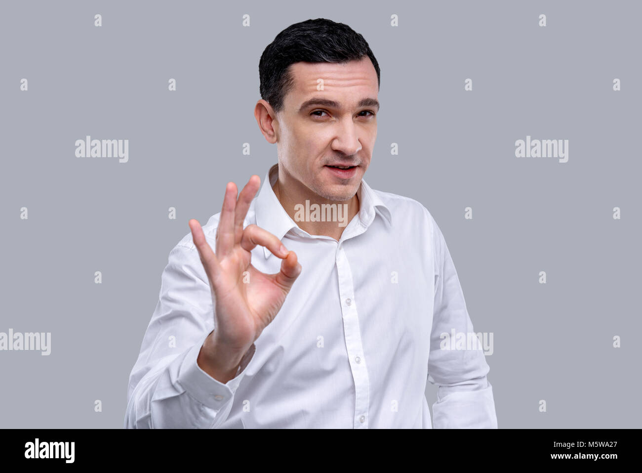 Pleased man showing ok with his fingers Stock Photo - Alamy