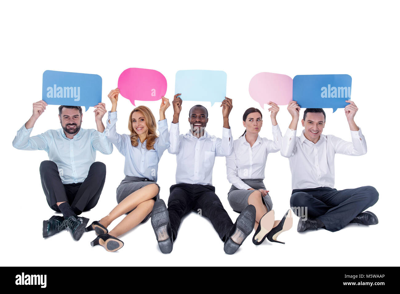 Happy co-workers holding tables over their heads Stock Photo - Alamy