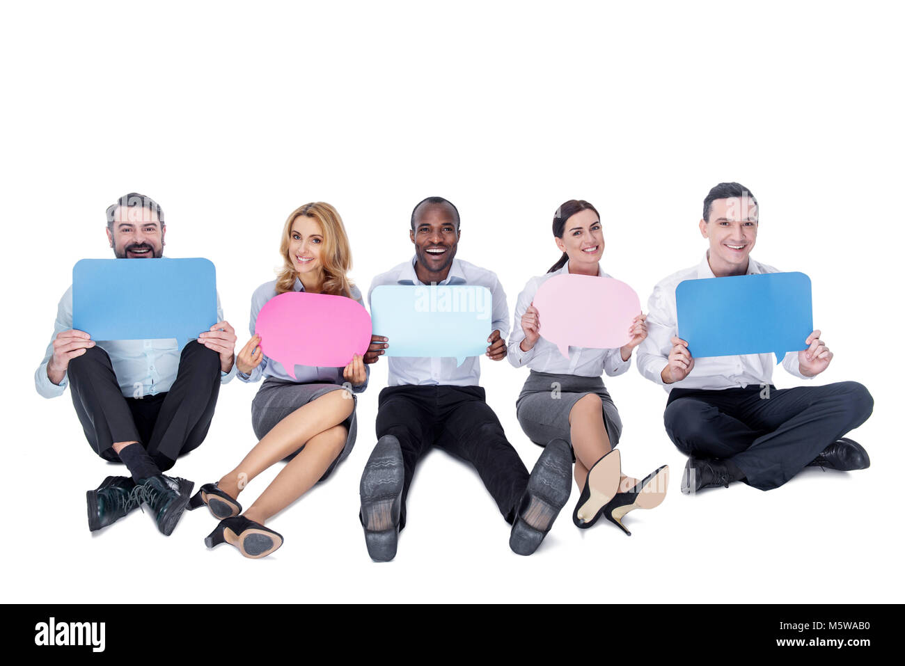 Inspired young co-workers holding tables Stock Photo - Alamy