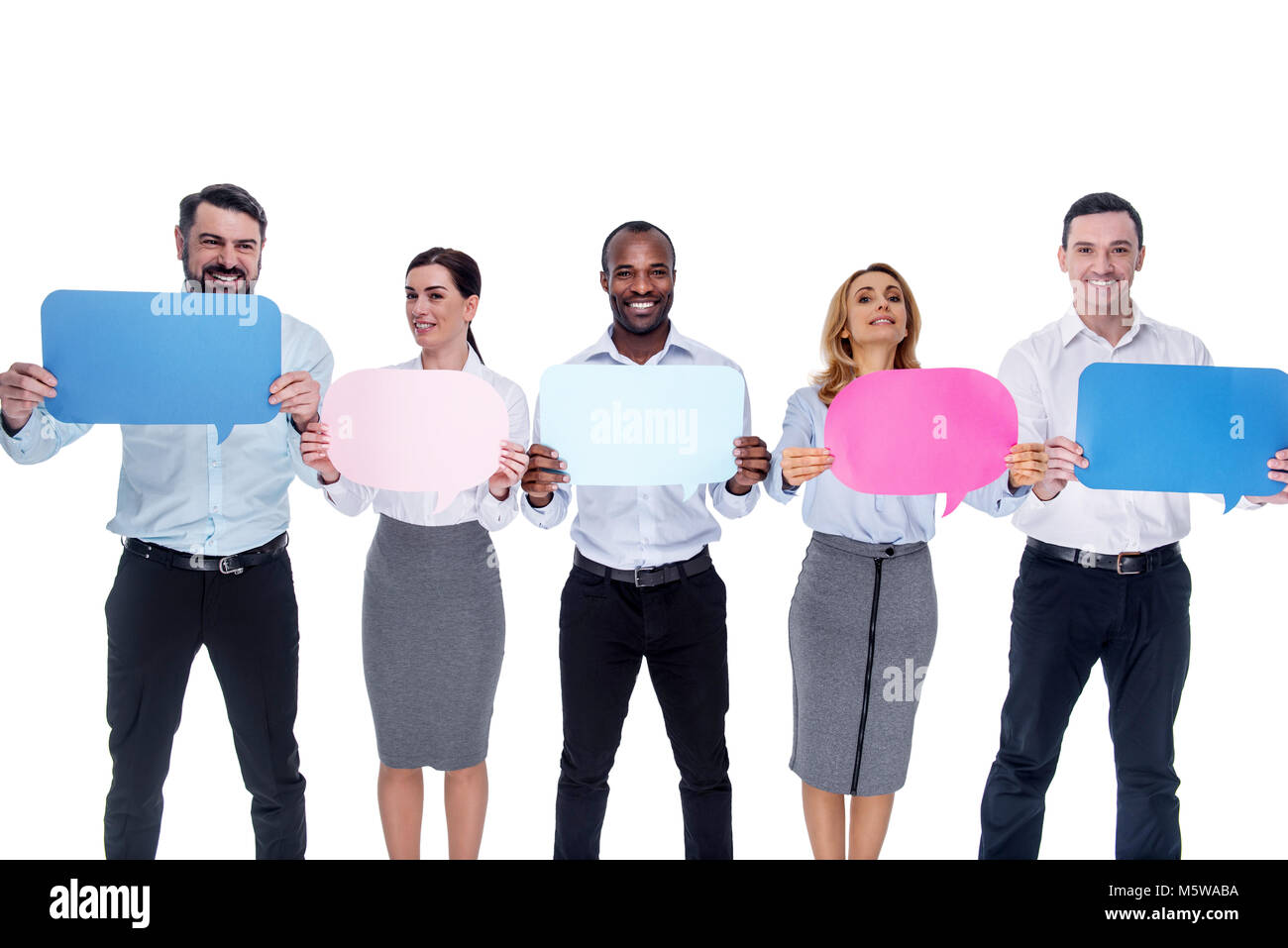 Smiling young co-workers holding tables Stock Photo - Alamy