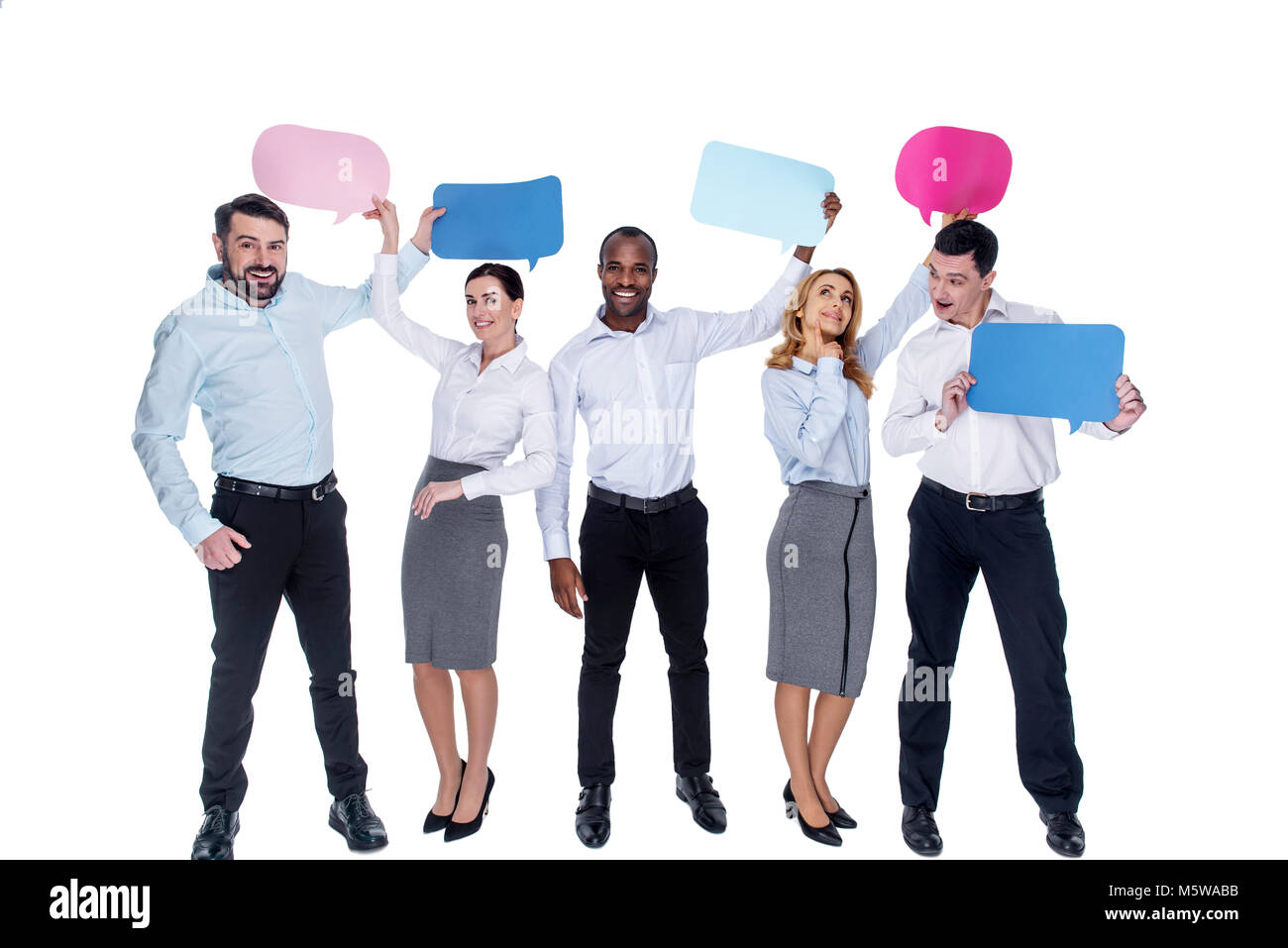 Cheerful co-workers holding tables over each others heads Stock Photo ...