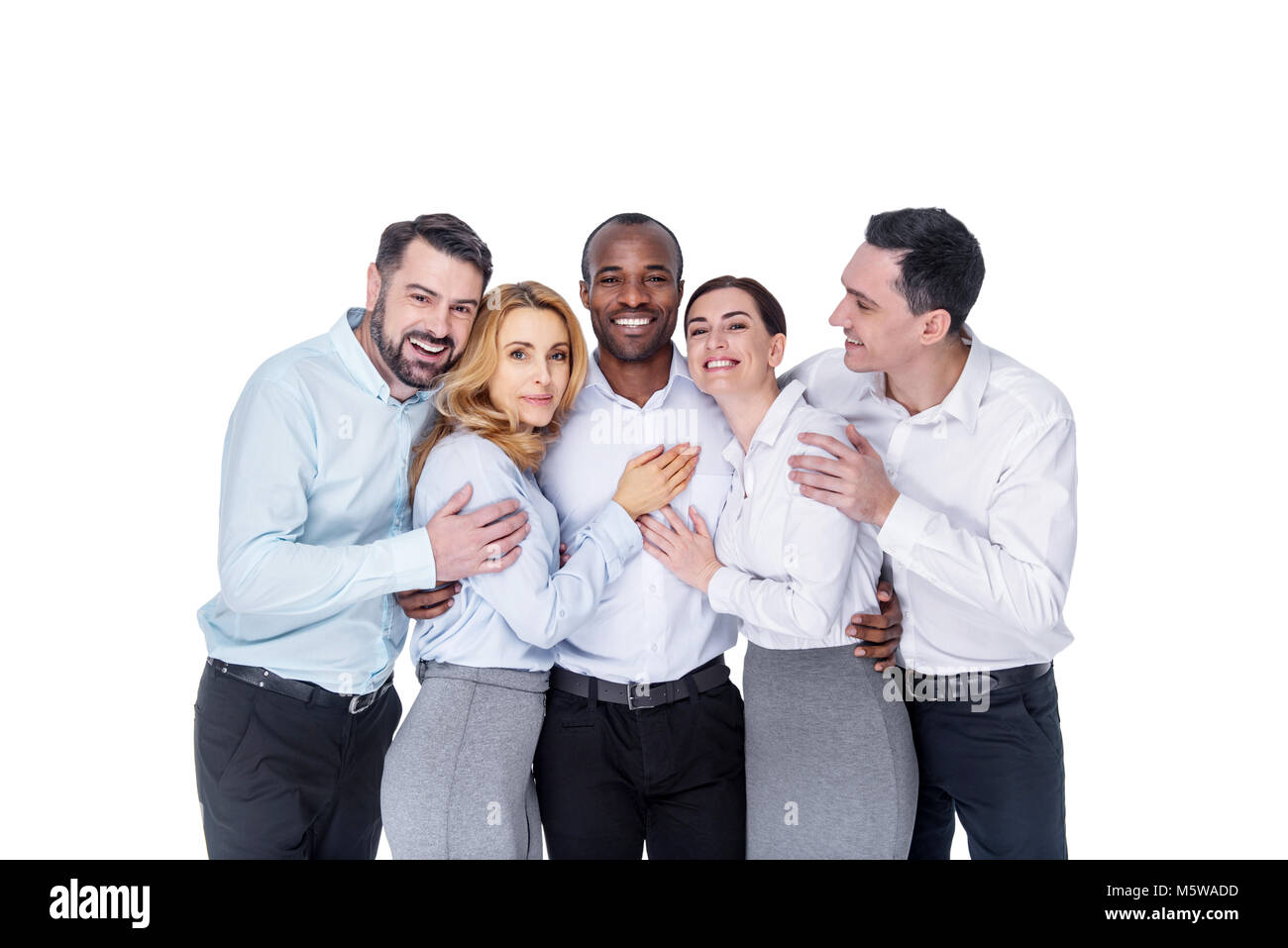 Happy colleagues standing together and hugging Stock Photo - Alamy