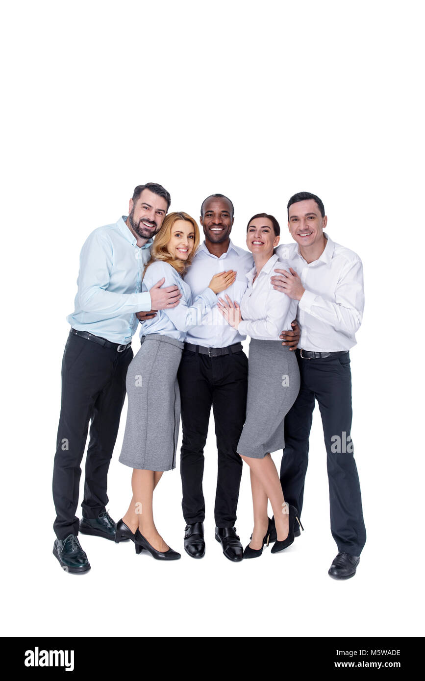 Inspired colleagues standing together and hugging Stock Photo - Alamy