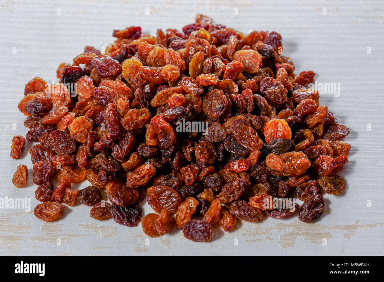 pile of organic raisins on a white wooden table Stock Photo - Alamy