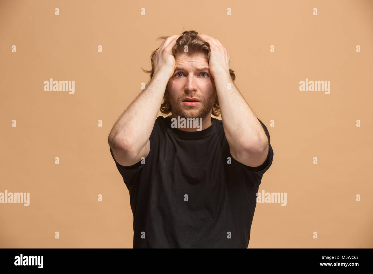 The young emotional angry and scared man standing and looking at camera ...