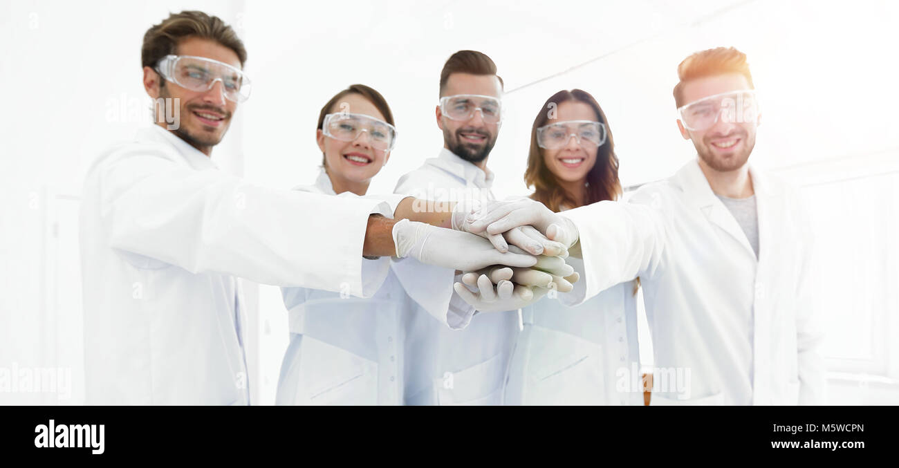 successful team of young scientists with hands clasped together Stock ...