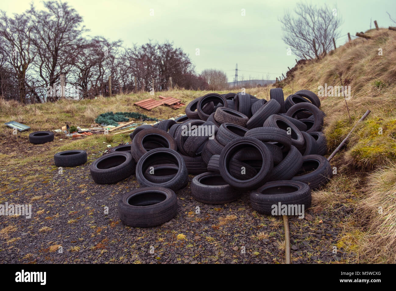 Dumped Tires, fly tipping on country lane Stock Photo - Alamy