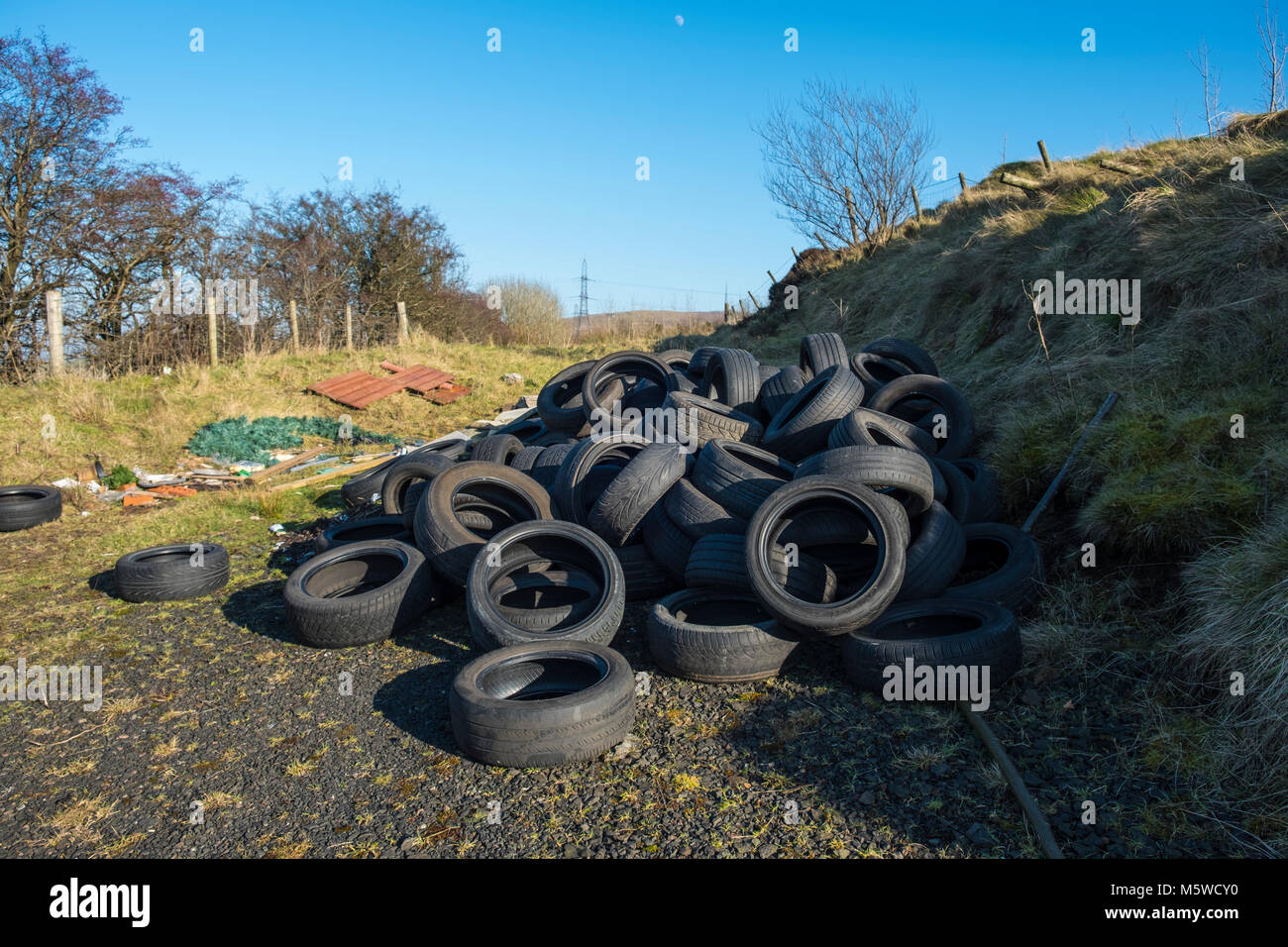 Dumped Tires, fly tipping on country lane Stock Photo - Alamy