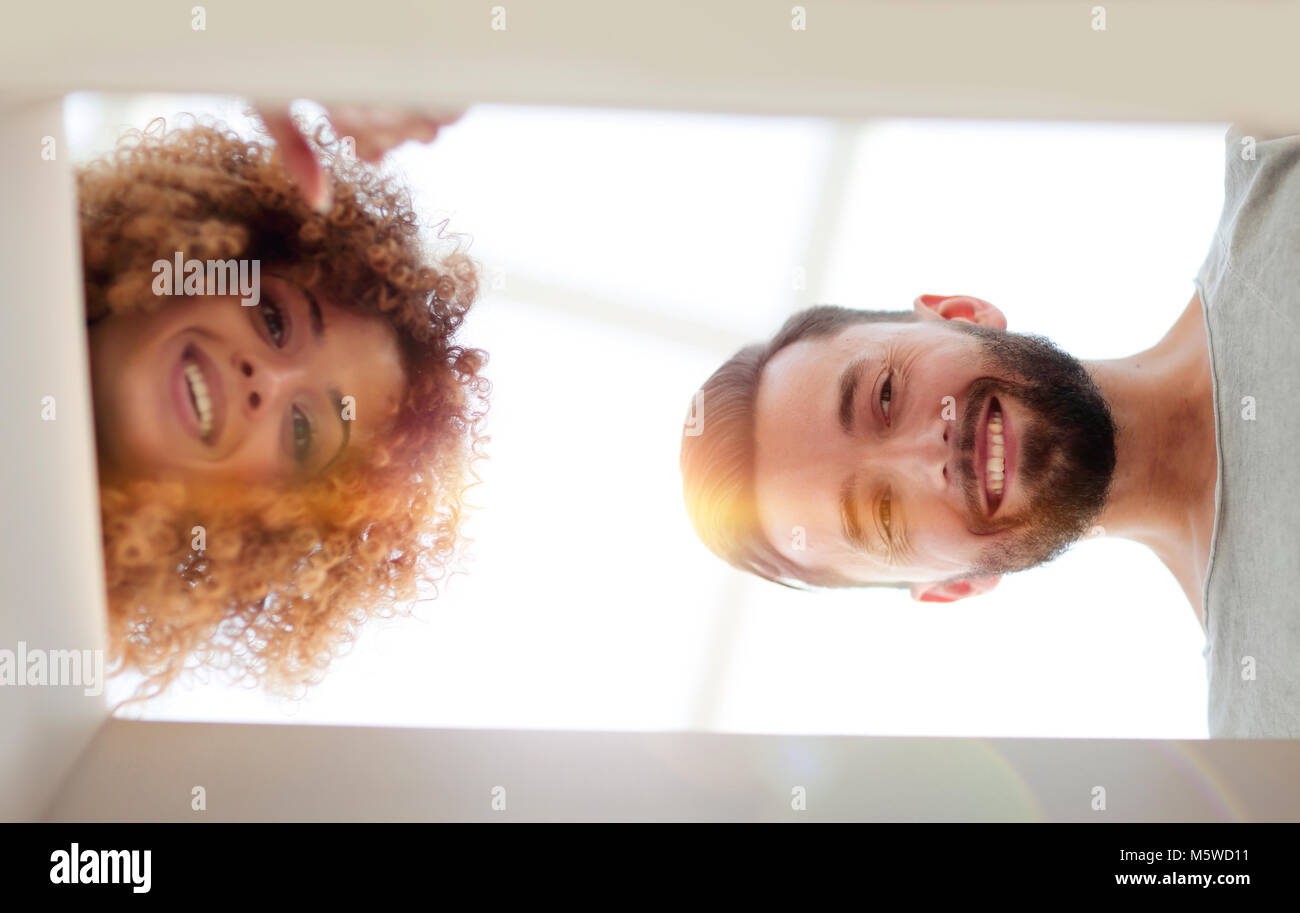 View from below a young couple looking inside the box Stock Photo - Alamy