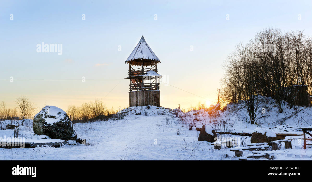 Wooden lookout tower stands on a snowy mountain. Winter landscape at ...