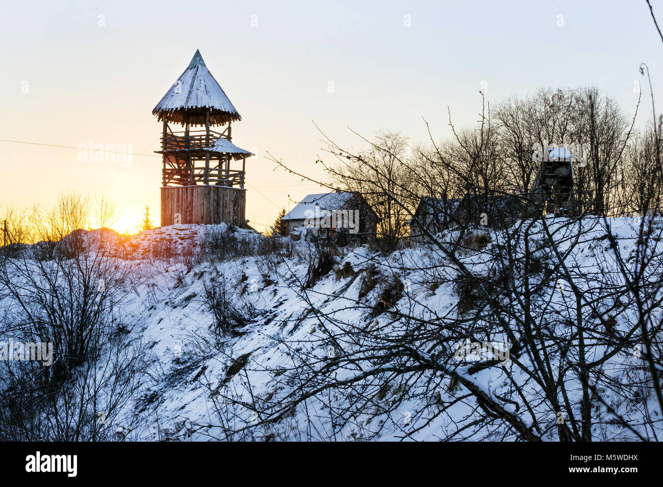 Wooden lookout tower stands on a snowy mountain. Winter landscape at ...