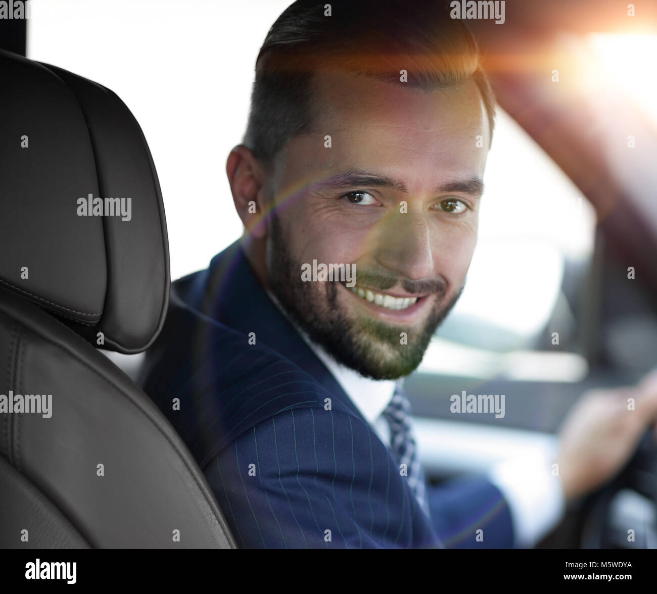 Handsome young man sitting in the front seat of a car looking at Stock ...