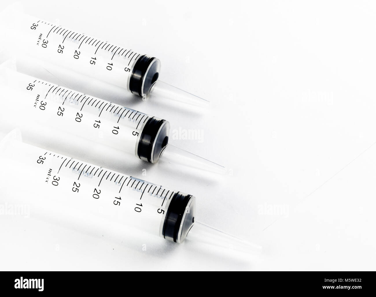 Industrial tapered tip syringes in a row side view Stock Photo - Alamy