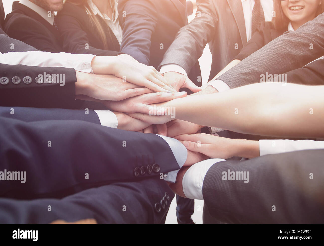 large business team standing with folded hands together Stock Photo - Alamy