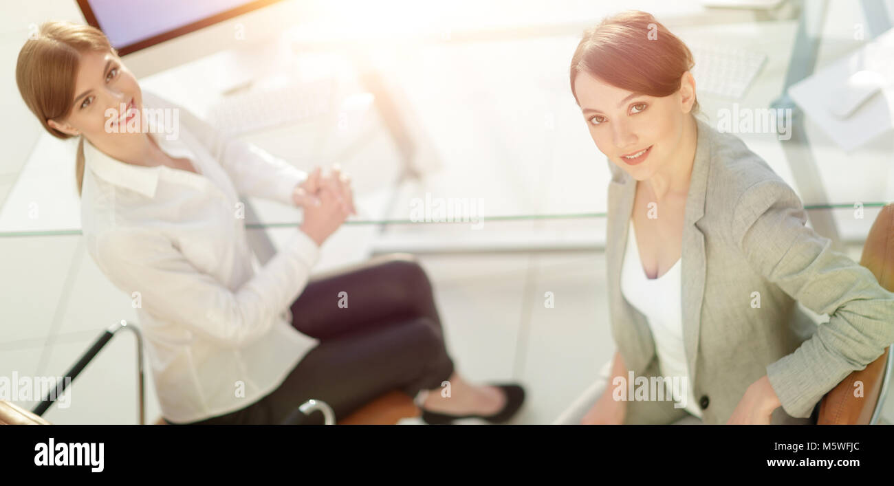 view from the top. two women colleagues sitting near the desktop Stock ...