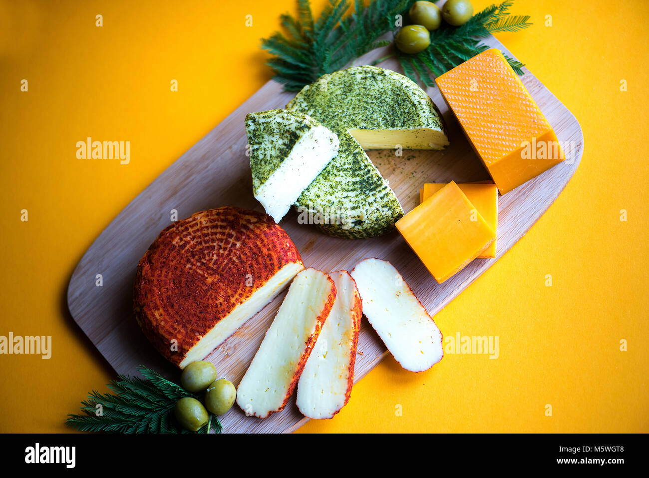 Mix cheese on wooden cutting board.Top view Stock Photo - Alamy