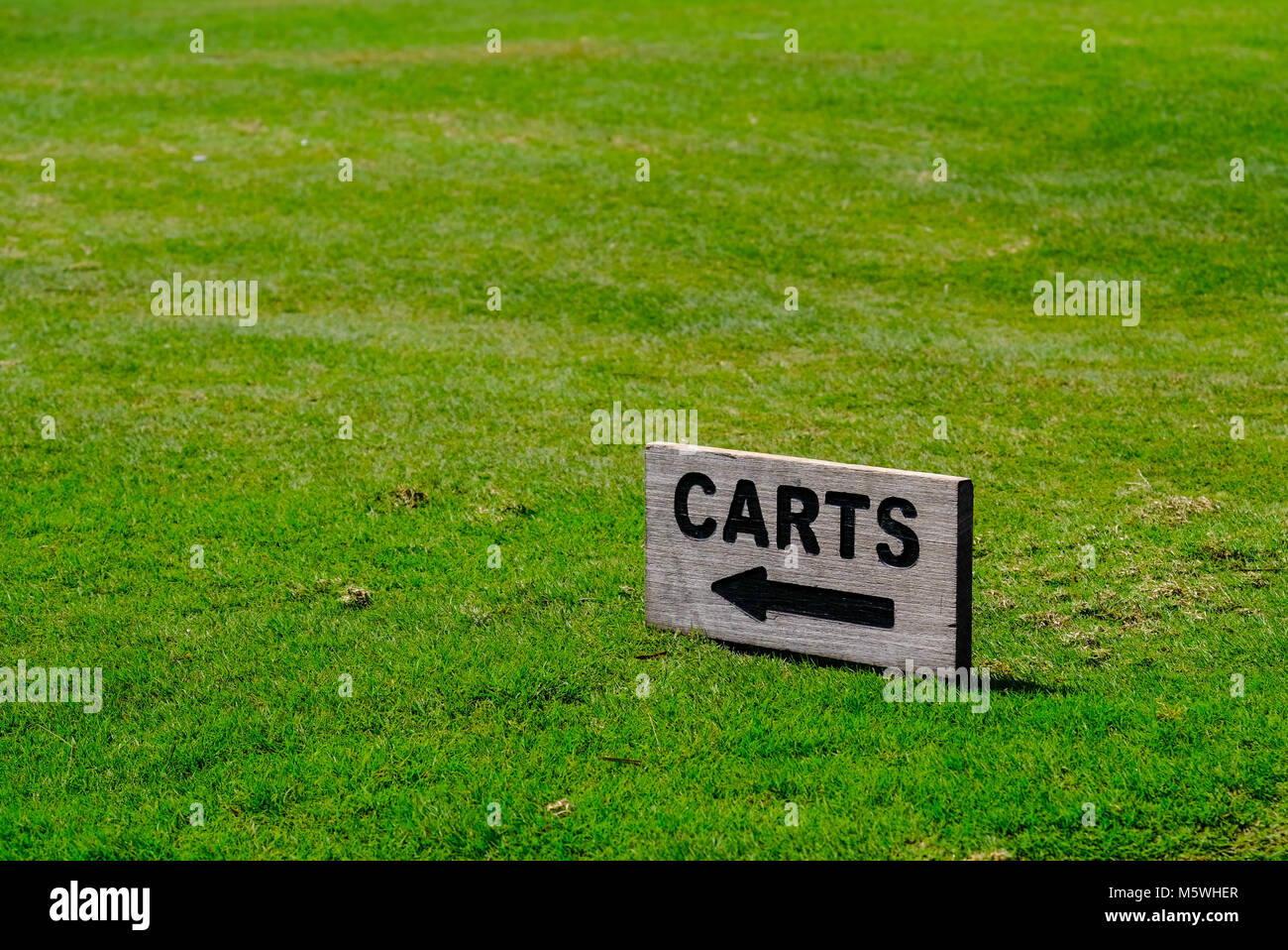 A small wooden Carts sign indicating with arrow to left at Golf Course ...