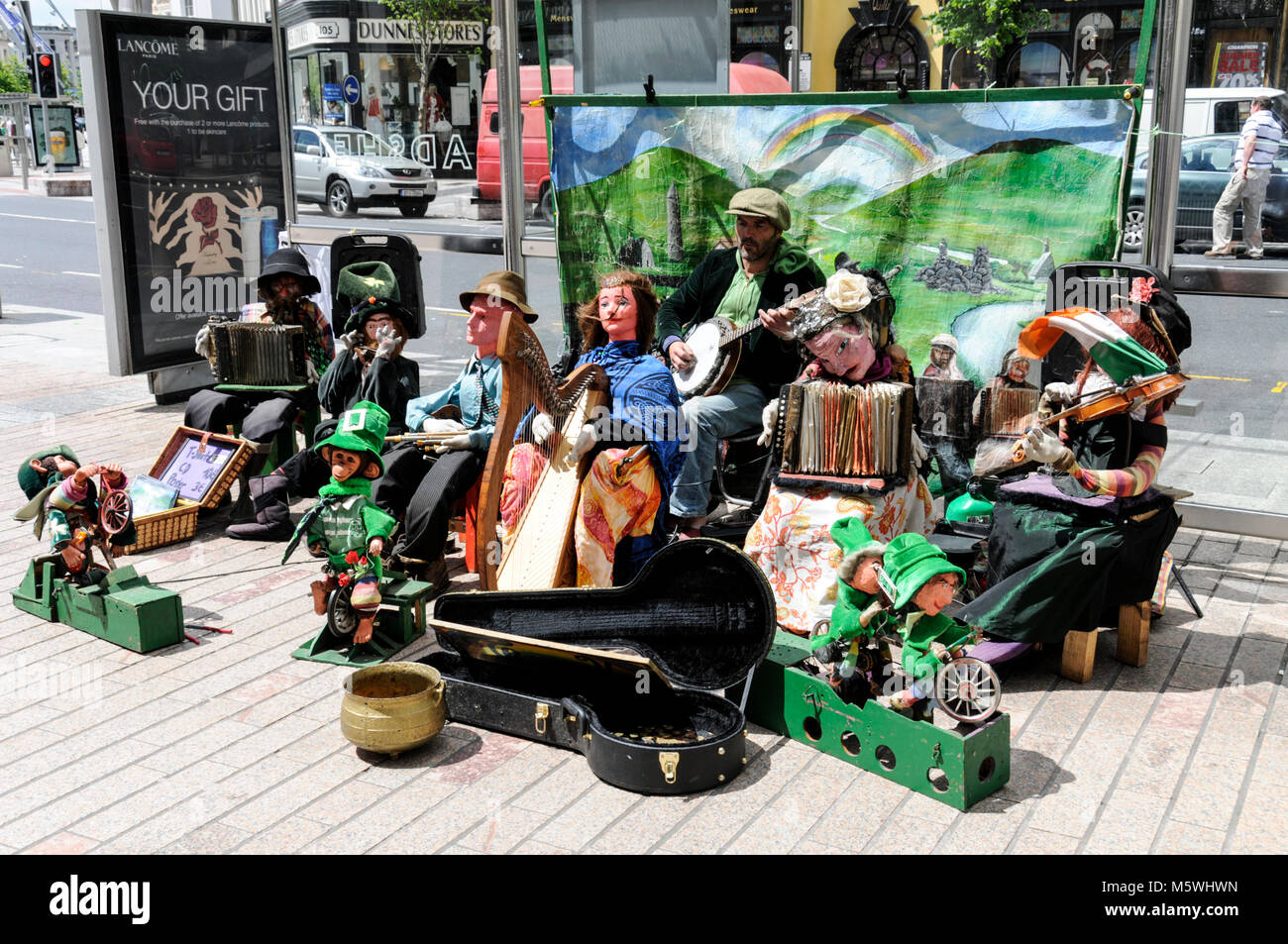 A busker using his puppets as part of his band, playing Irish music and ...