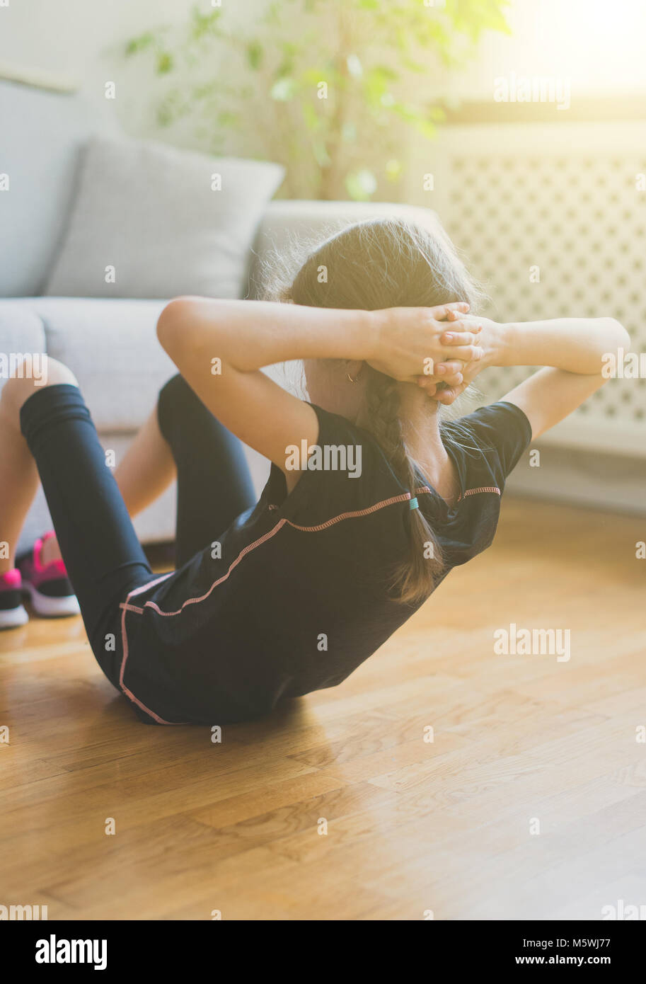 Little girl doing exercises for the abs at home Stock Photo - Alamy