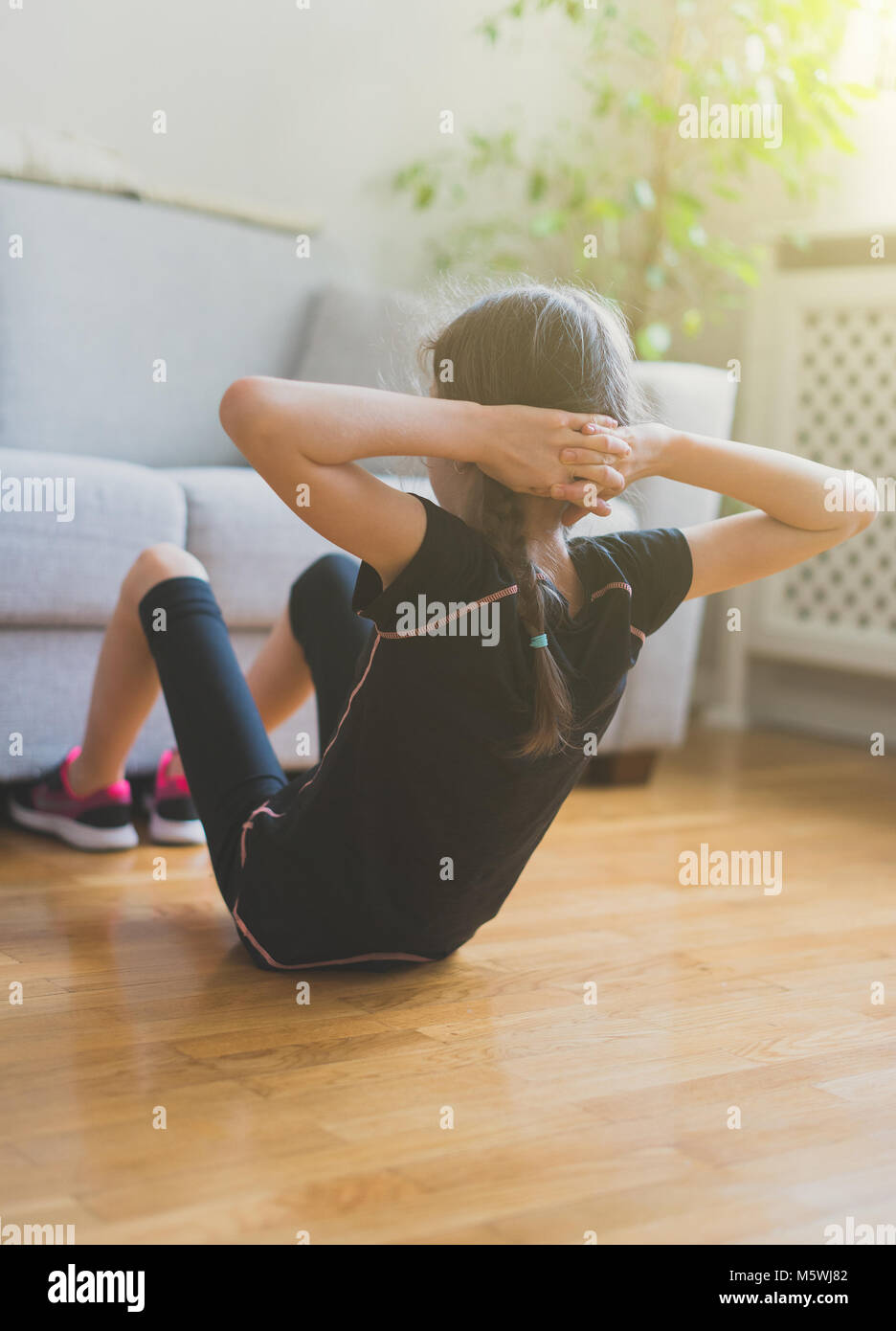 Little girl doing exercises for the abs at home Stock Photo - Alamy