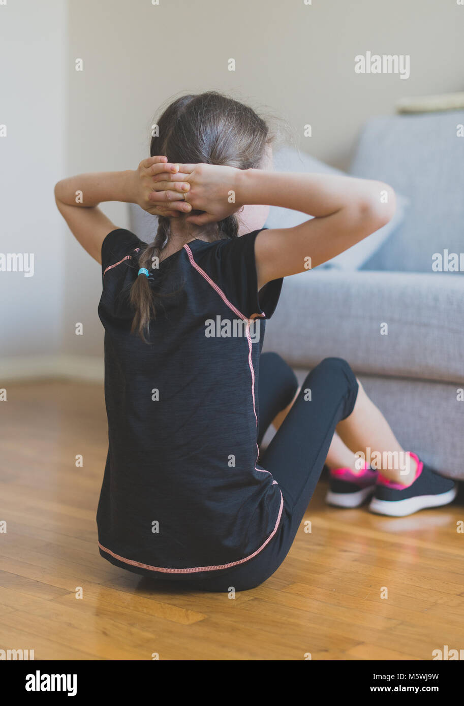 Little girl doing exercises for the abs at home Stock Photo - Alamy