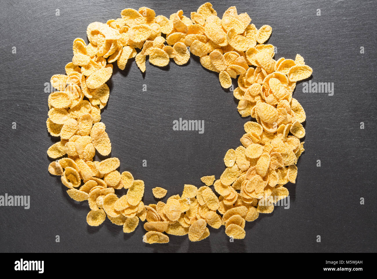 cornflakes with space for text, flakes scattered ring on slate board ...
