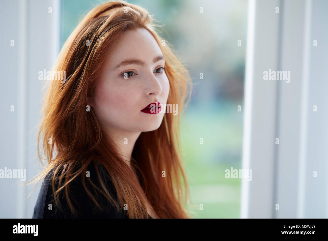 Attractive red haired girl thinking Stock Photo - Alamy