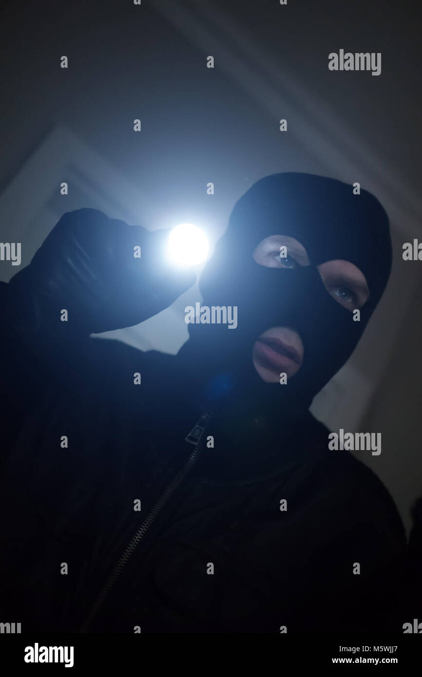 Thief wearing mask with a flashlight in the house Stock Photo - Alamy