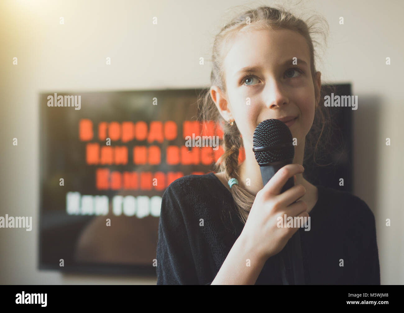 Cute little girl singing karaoke at home Stock Photo - Alamy