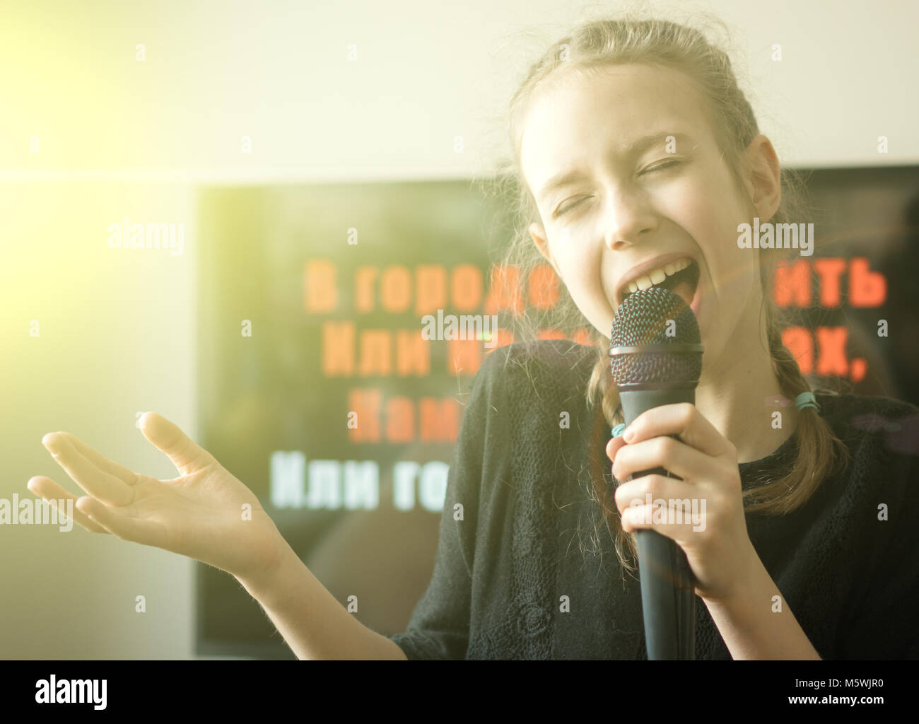 Cute little girl singing karaoke at home Stock Photo - Alamy