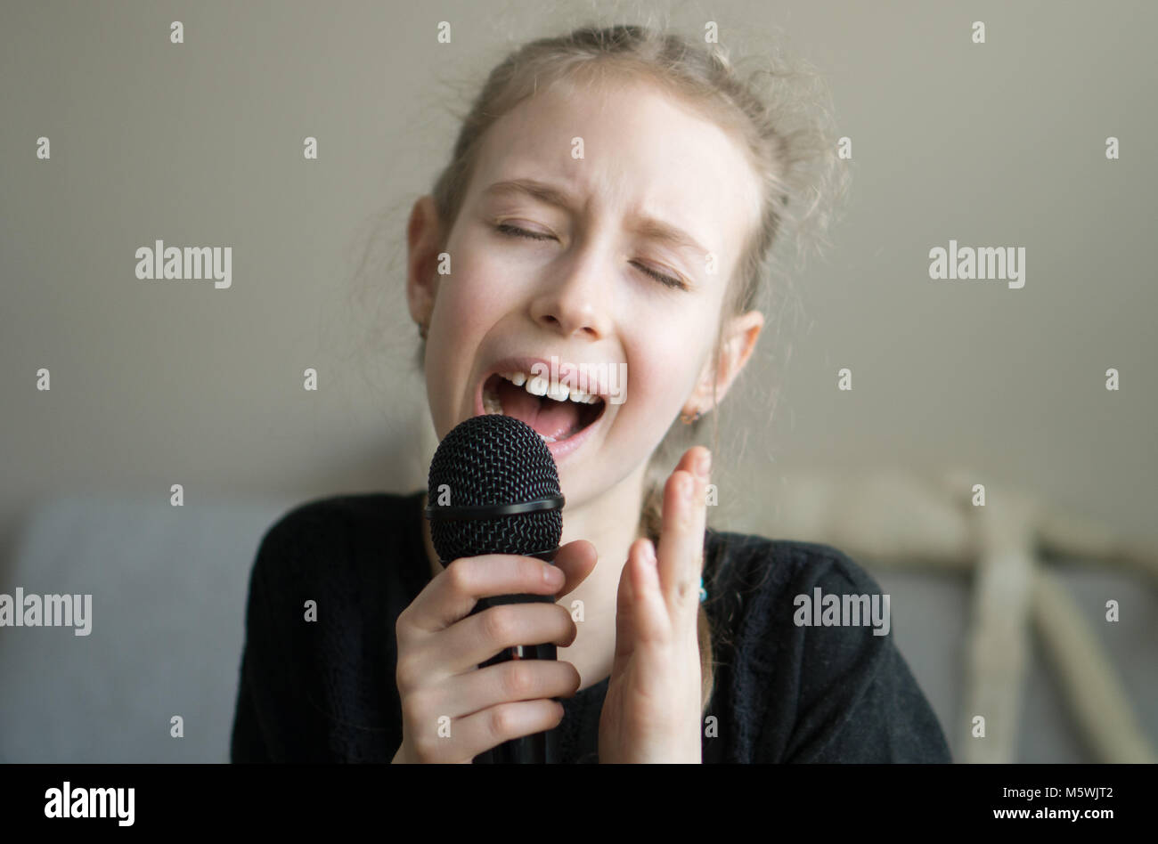 Cute little girl singing karaoke at home Stock Photo - Alamy