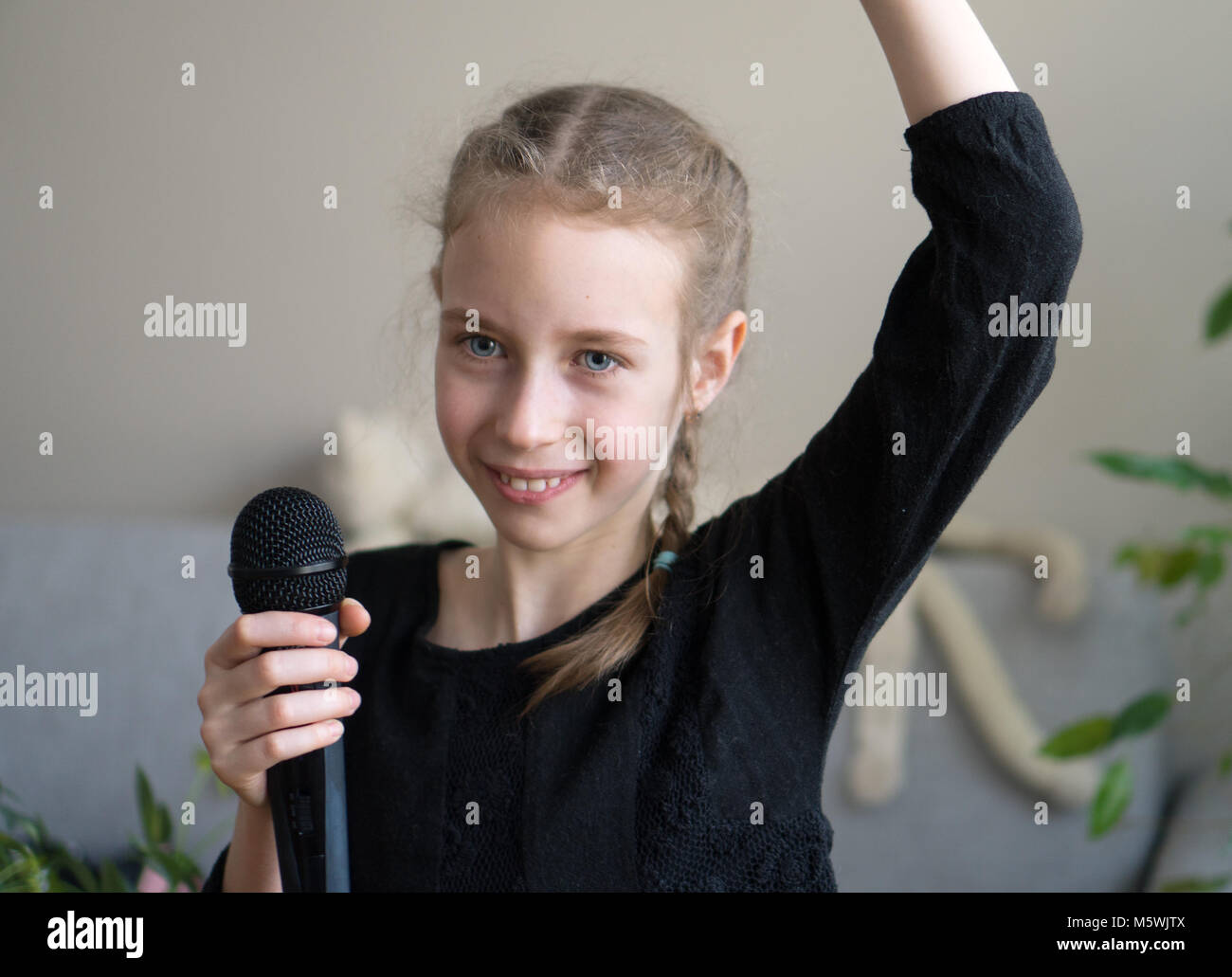 Cute little girl singing karaoke at home Stock Photo - Alamy