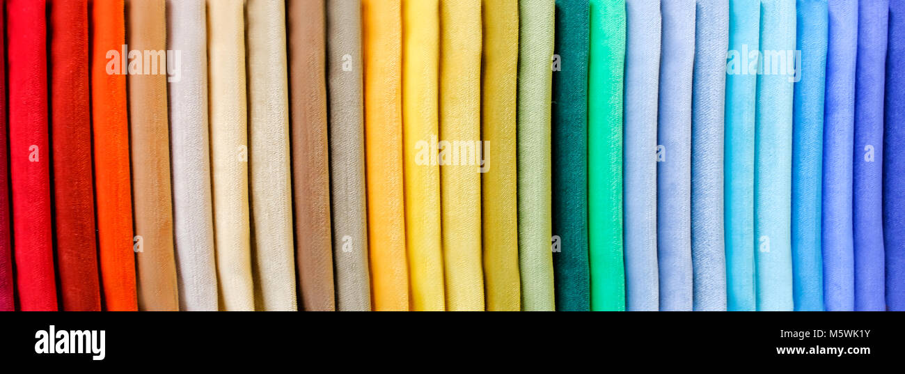 Rainbow clothes background. Pile of bright folded clothes Stock Photo ...
