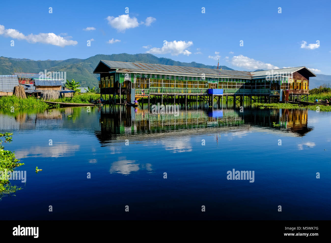 A school building is built on stilts between the swimming gardens in ...