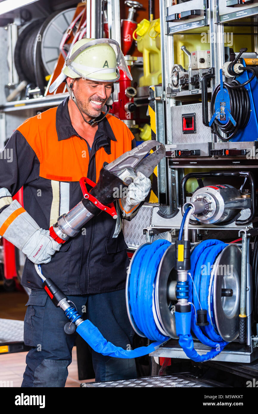 Fire fighter checking hydraulic cutter at fire engine Stock Photo - Alamy