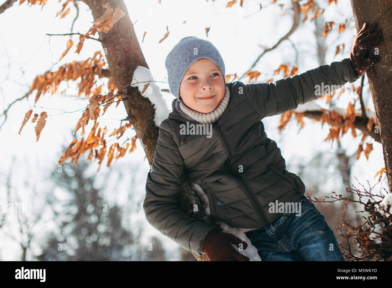 Boy have fun and smile to the camera. Smile and close eyes with snow ...