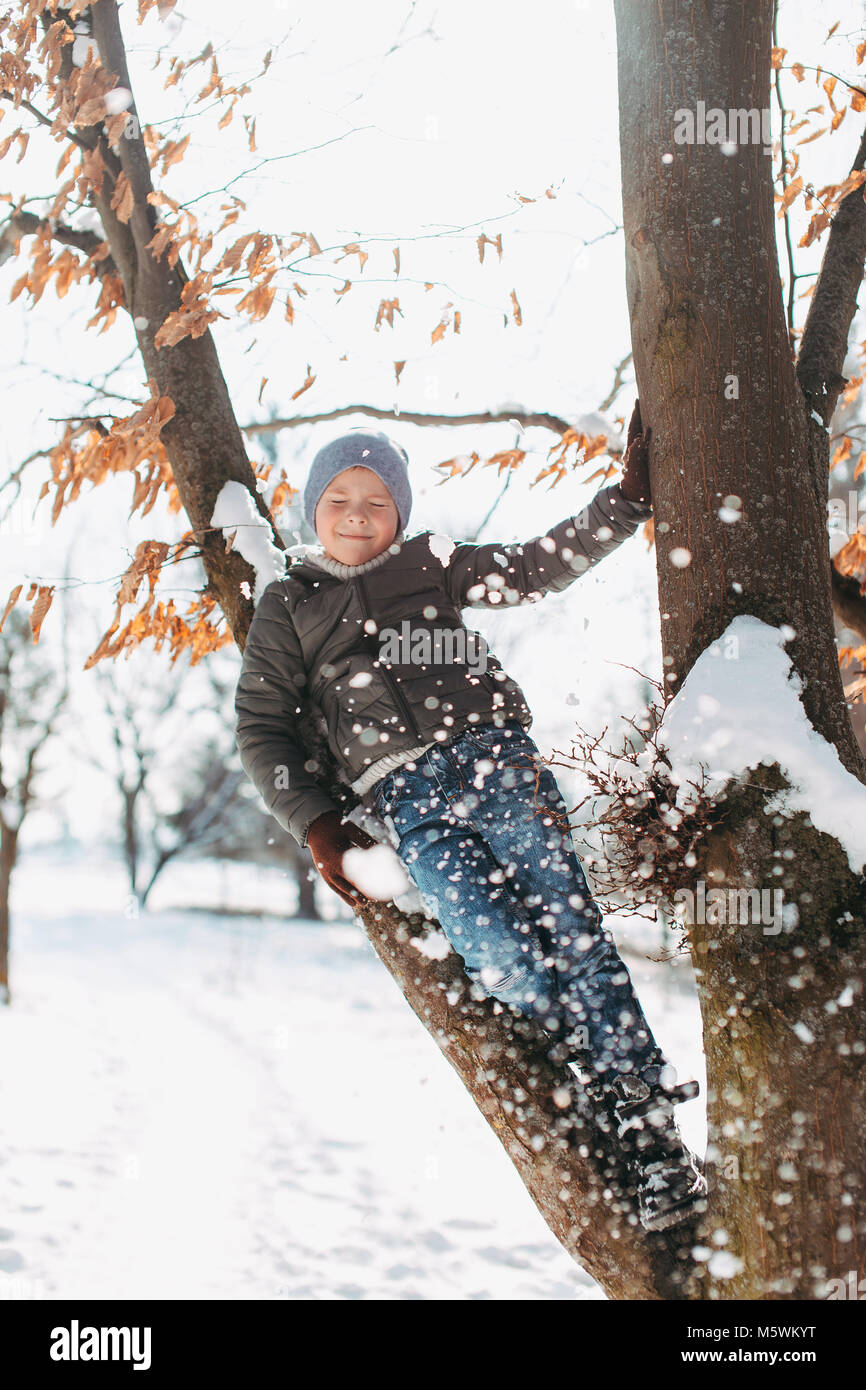Boy have fun and smile to the camera. Smile and close eyes with snow ...