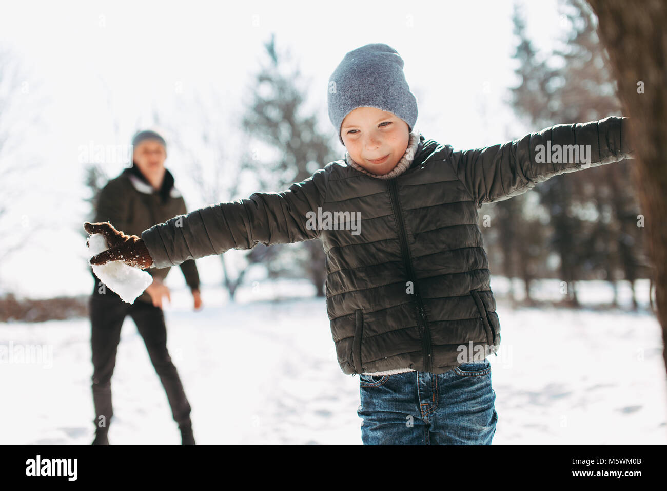 Boy have fun and smile to the camera. Smile and close eyes with snow ...