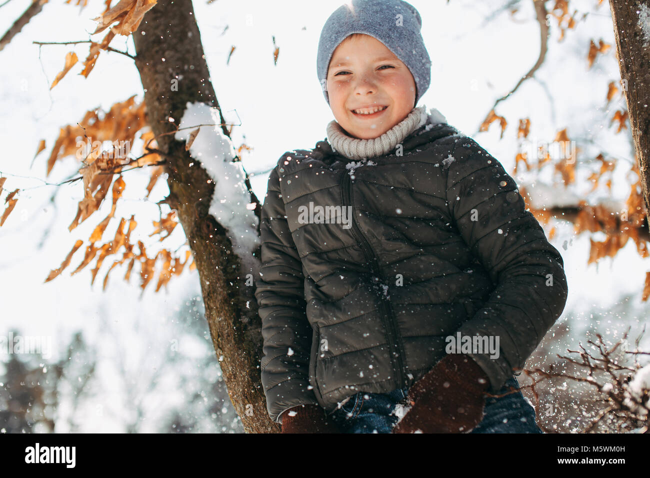 Boy have fun and smile to the camera. Smile and close eyes with snow ...