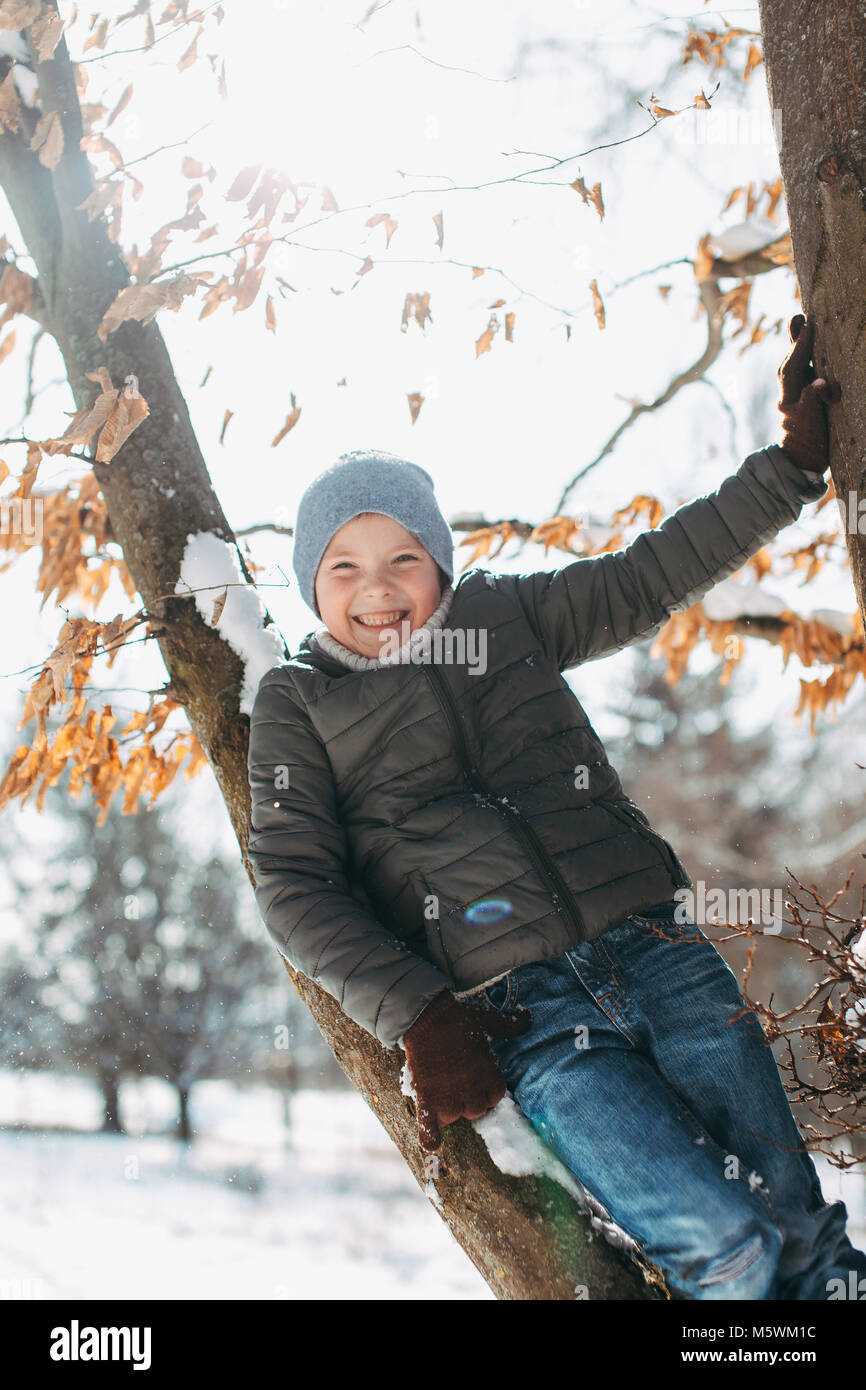 Boy have fun and smile to the camera. Smile and close eyes with snow ...