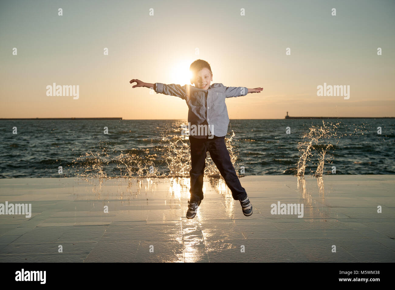healthy little kid jumping on sea with waves background Stock Photo - Alamy