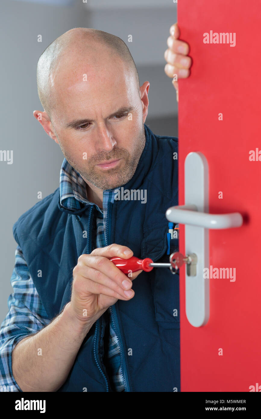 Man fixing lock on internal door Stock Photo - Alamy